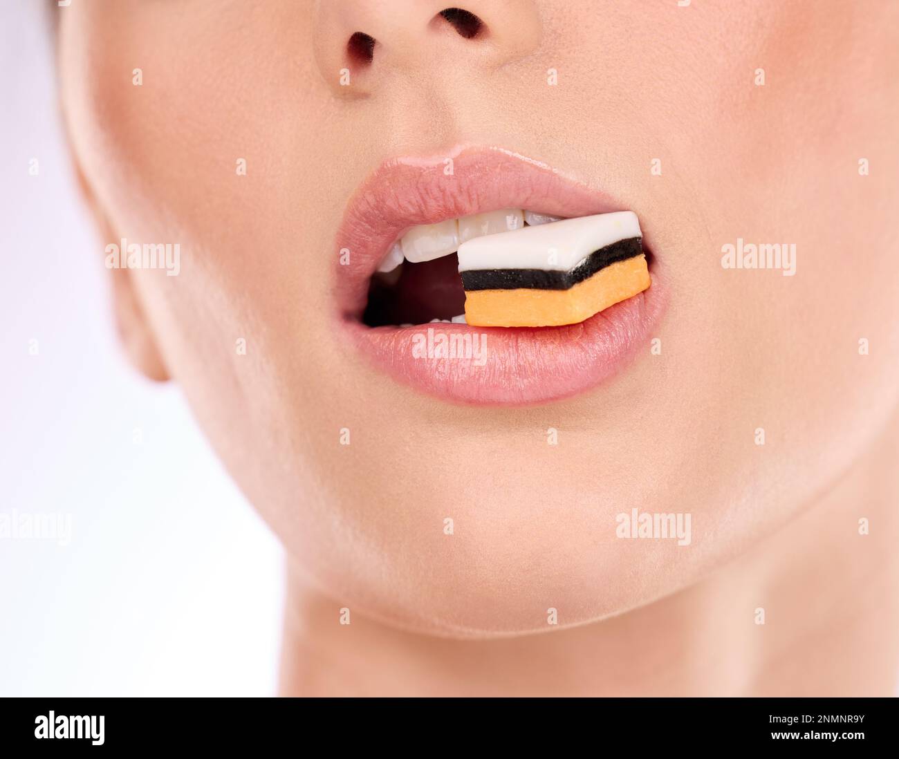 Liquorice, woman eating and mouth with makeup and cosmetics in an ...