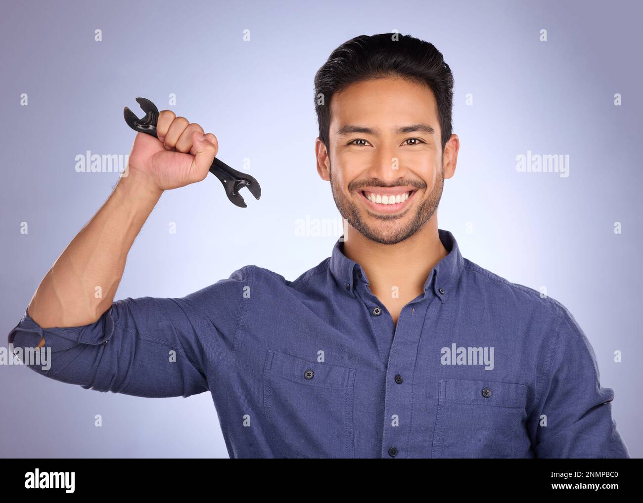 Portrait of man holding wrench isolated on studio background for repair ...