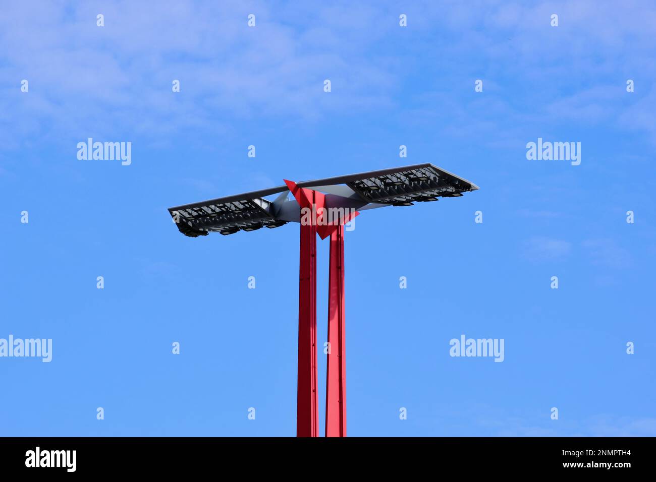 flat solar panel on top of red steel light pole or pylon. photovoltaic ...