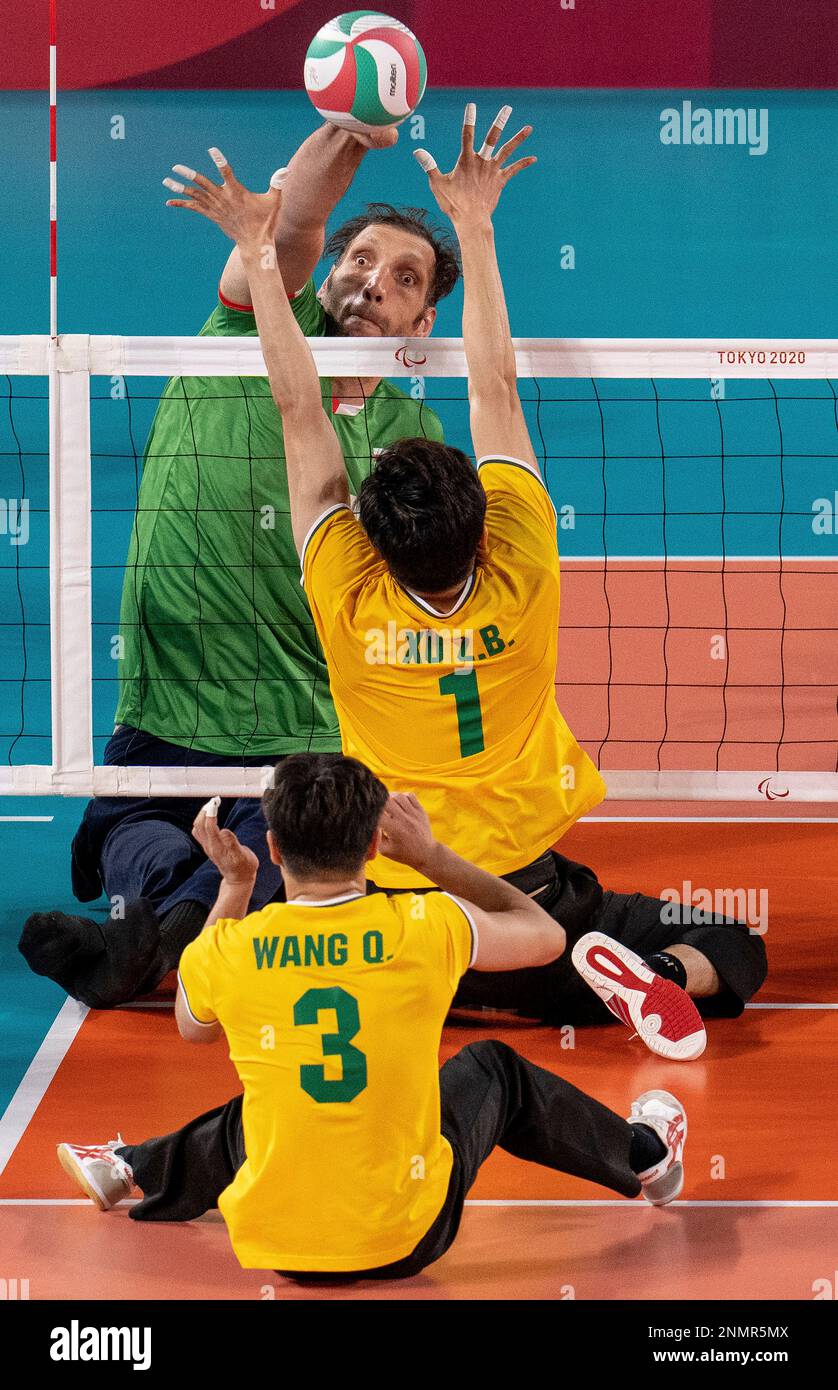Iran's Morteza Mehrzadselakjani spikes the ball as China's Xu Zengbing ...