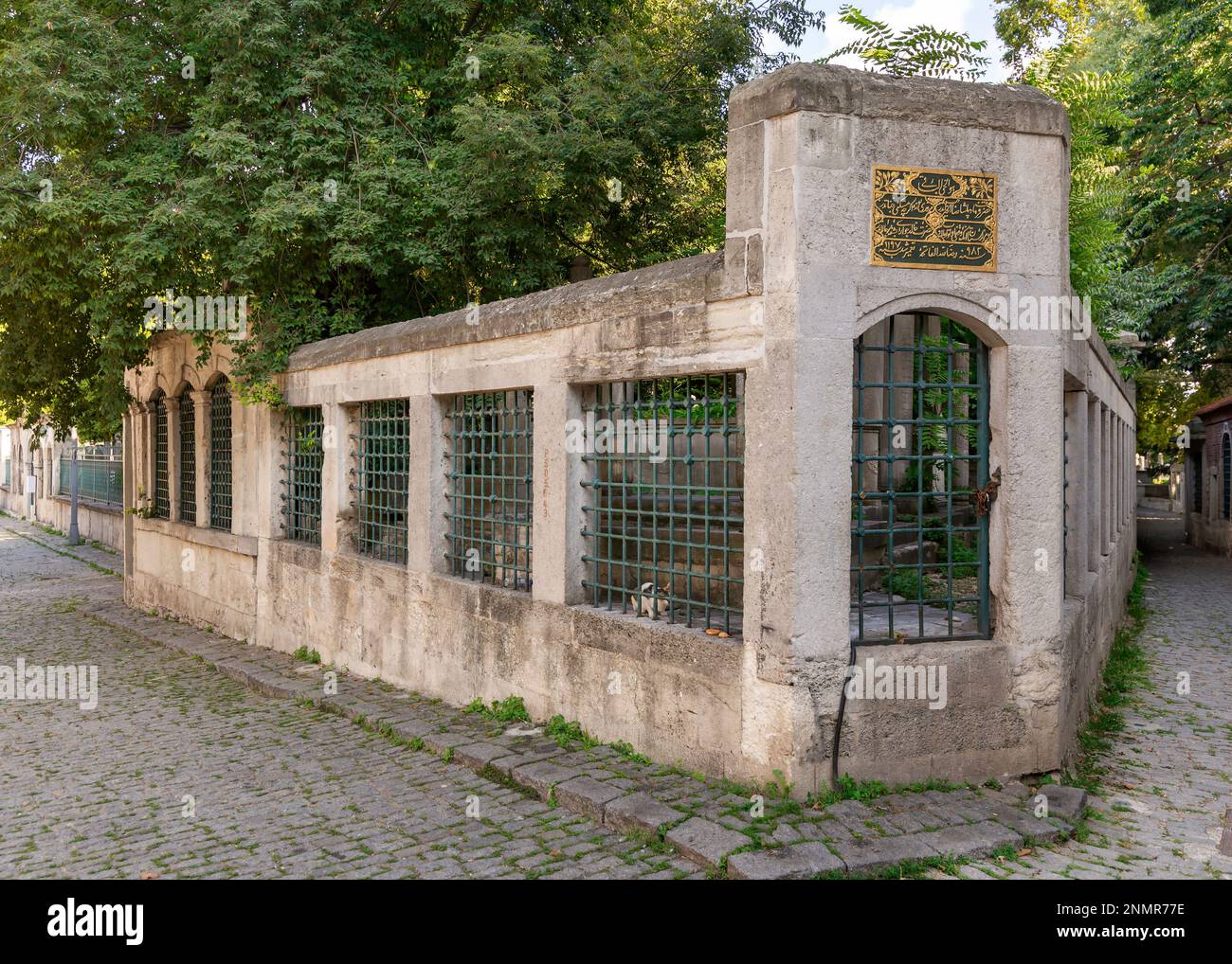 Cobblestone alley at Eyup Sultan Cemetery, with stone fence built of ...