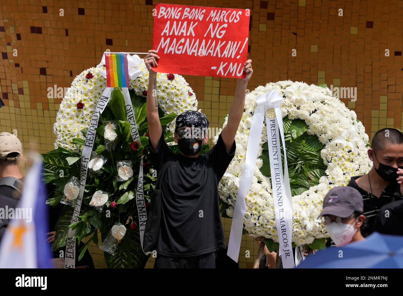 A protester holds a slogan that reads, "Bongbong Marcos, the son of a ...