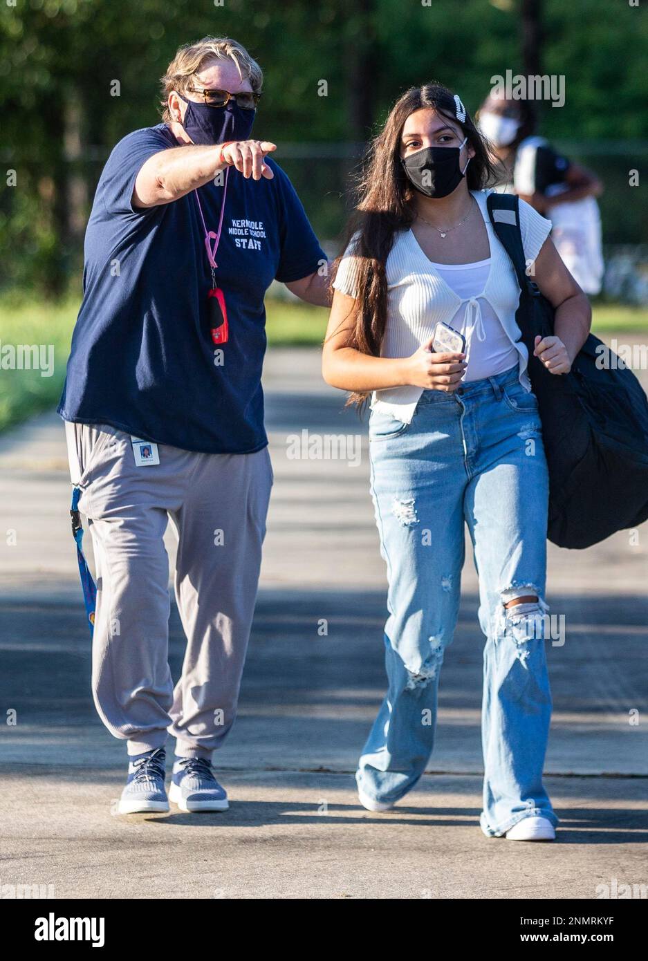 Teacher Bobbi Lucas directs a student to the entrance on the first day ...