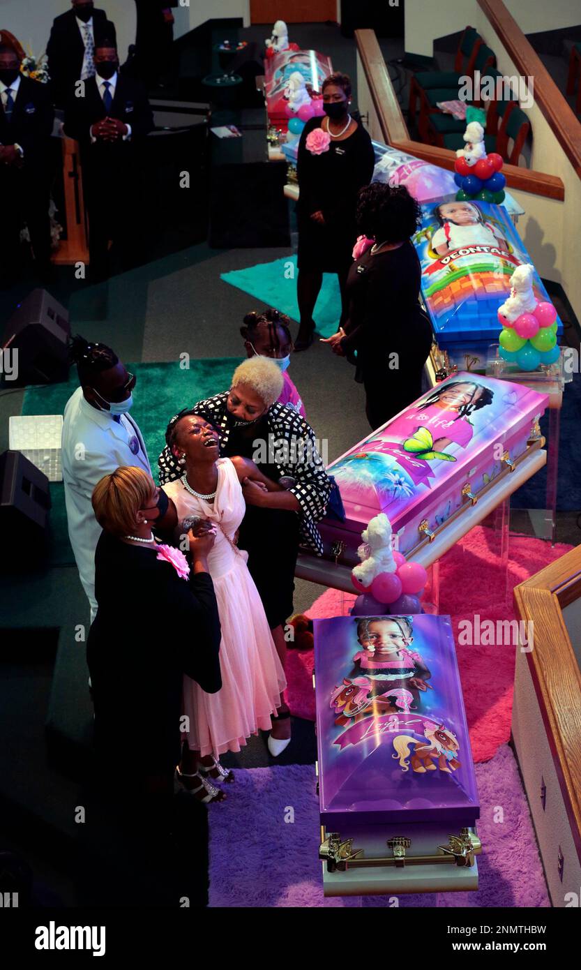 Sabrina Dunigan cries out as she visits the caskets of her children ...