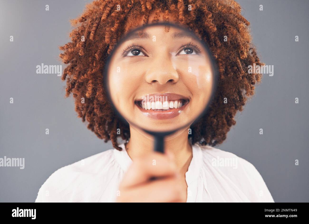 Funny, smile and black woman with a magnifying glass on face isolated ...