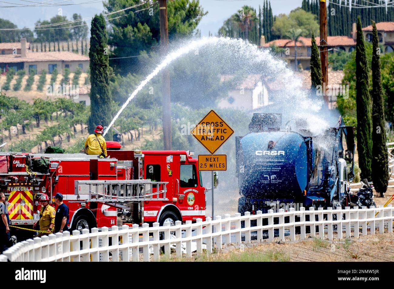 Firefighters extinguish a trash truck that caught fire and exploded at ...