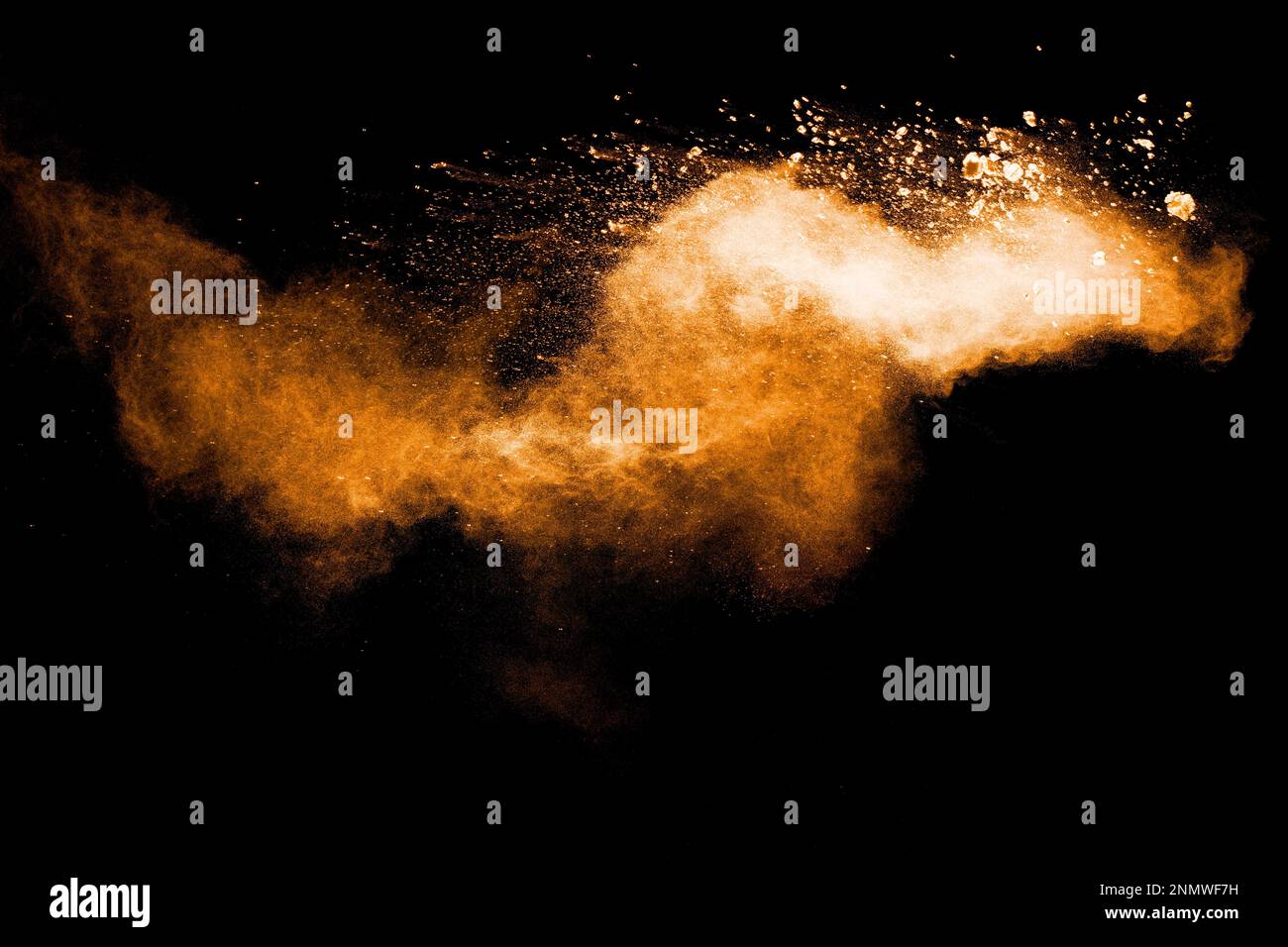 Abstract orange powder explosion on black background. Freeze motion of ...