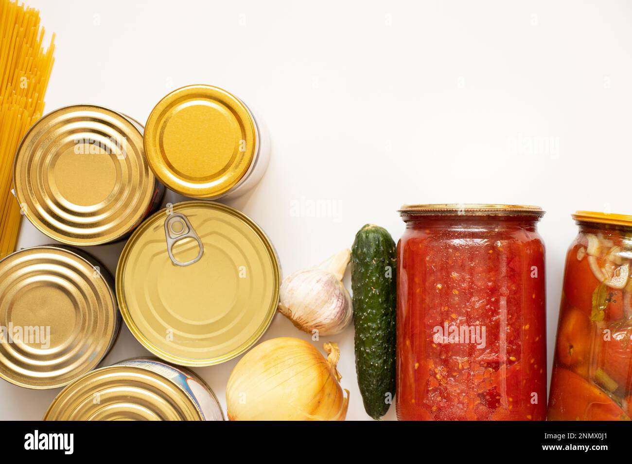 Different canned food, spaghetti and onions, cucumber and garlic and ...