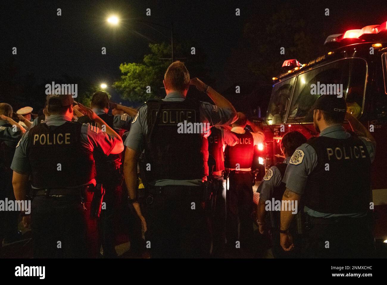 Chicago police officers salute as a procession for a police officer who ...