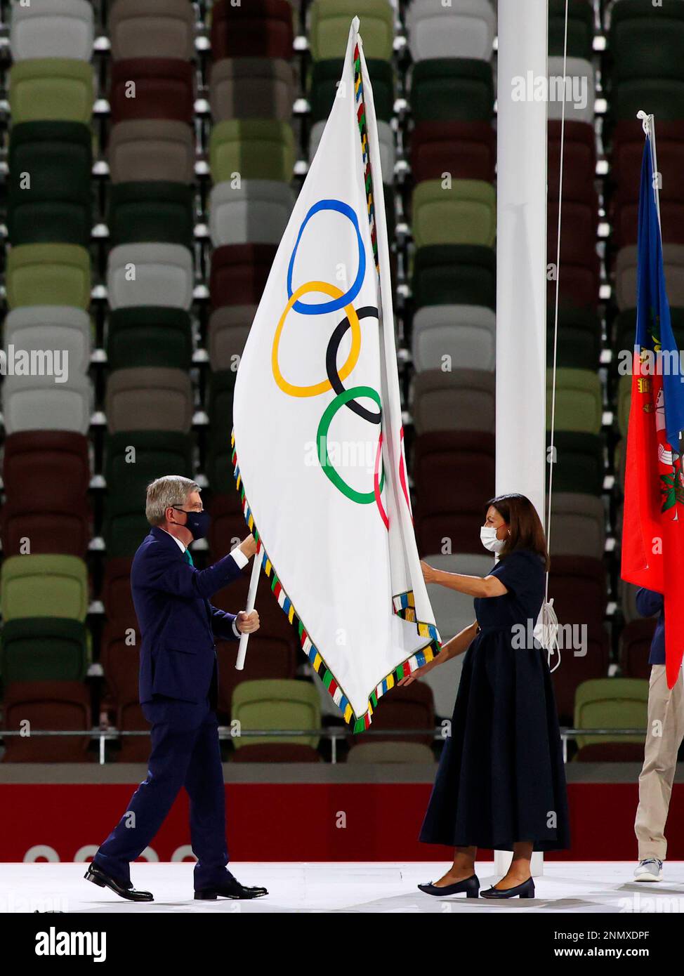 Paris Mayor Anne Hidalgo (R) receives the Olympic flag from IOC ...