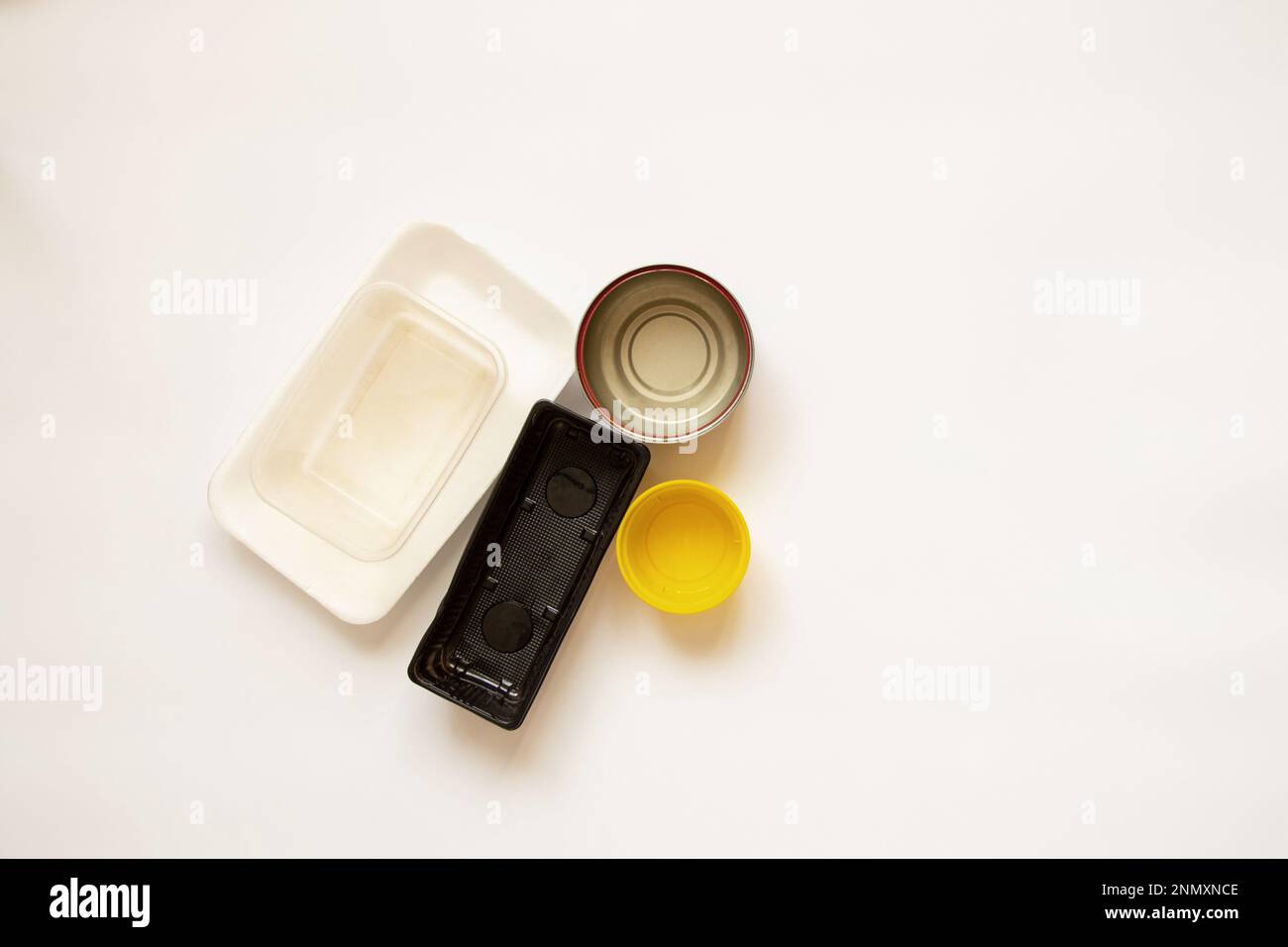 Various plastic and canned jars and old packages lie on a white ...