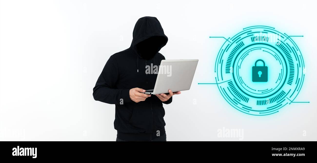 Male programmer in black hoodie stands and holds laptop. Hacker with ...