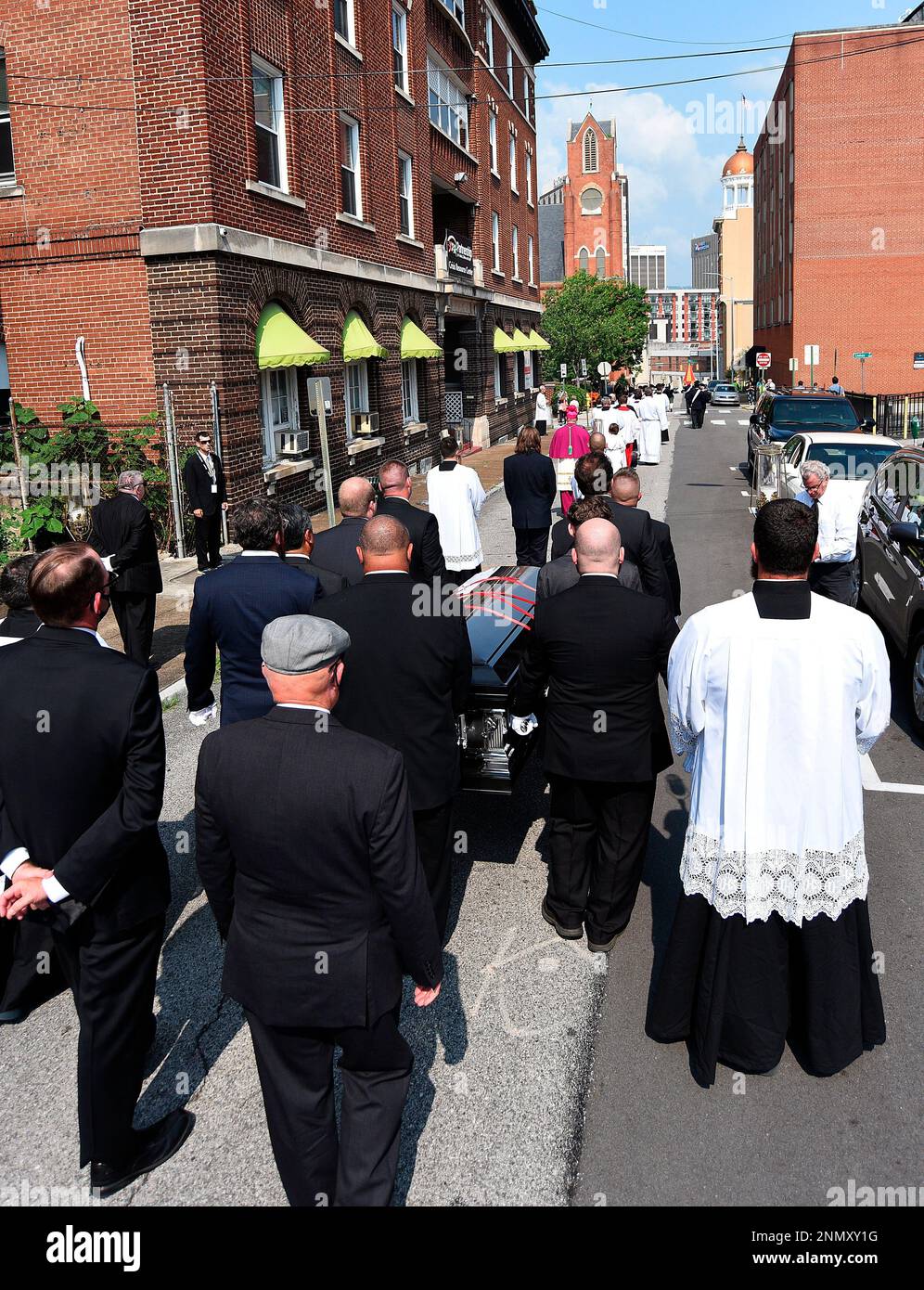 Pallbearers carry the remains of the Rev. Patrick Ryan down East 8th ...