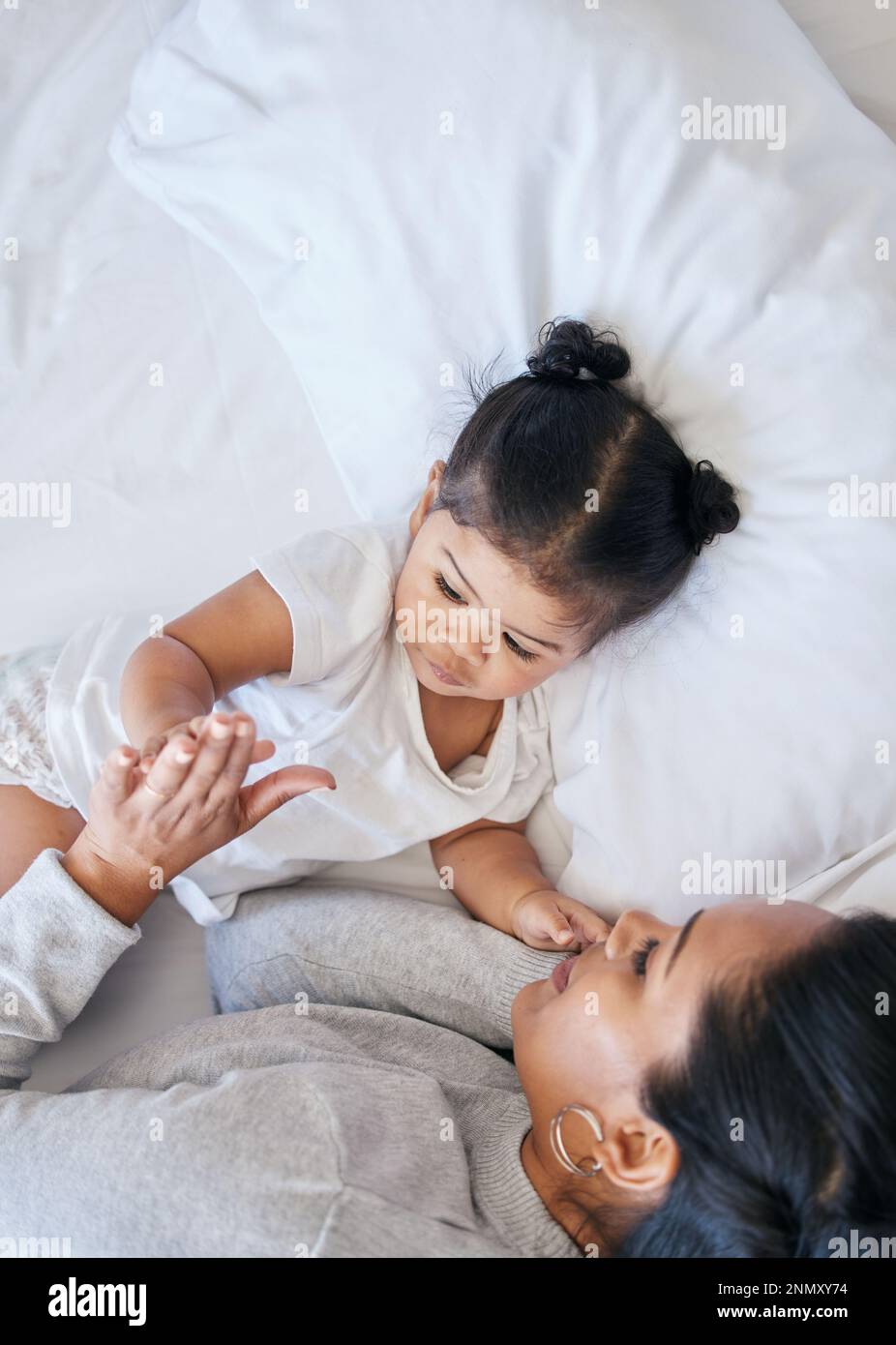 Baby, mother care and girl in a bedroom bed with parent support and ...
