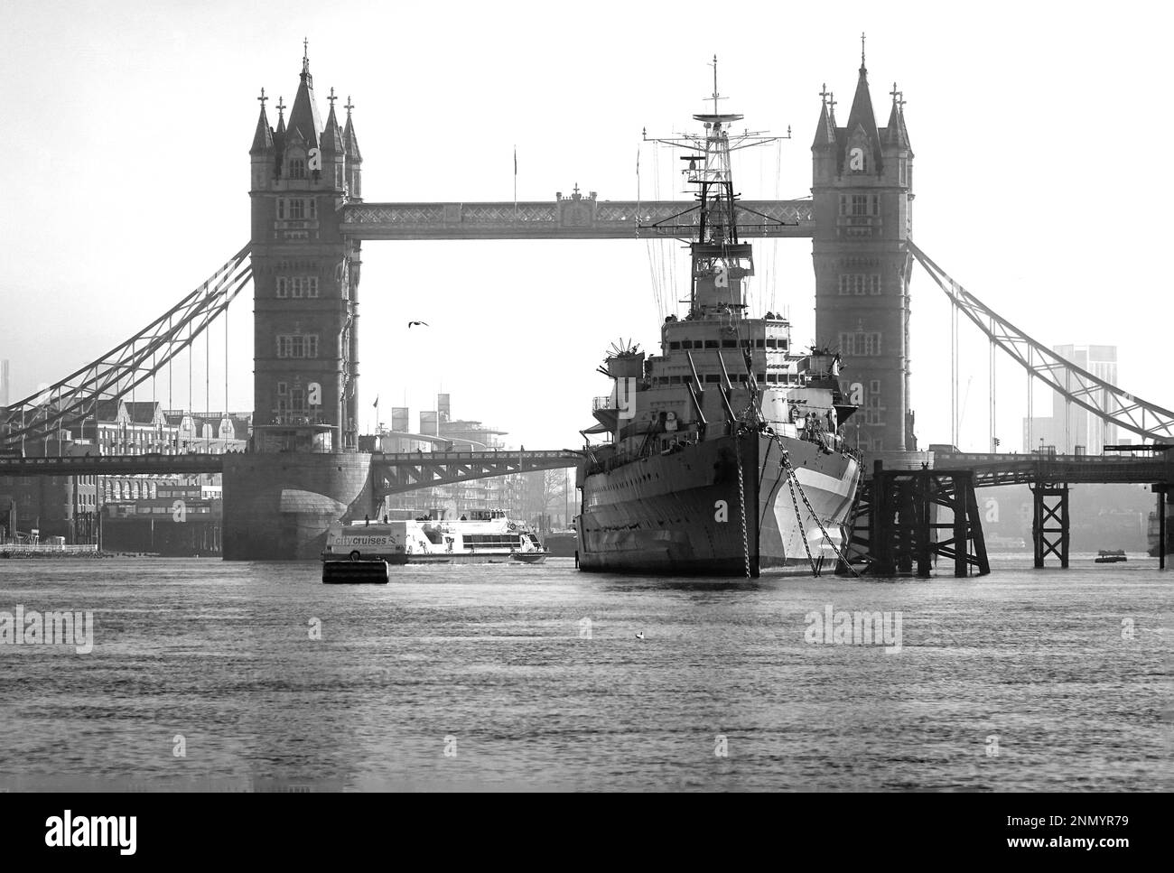 HMS Belfast moored on the River Thames with Tower Bridge in the ...