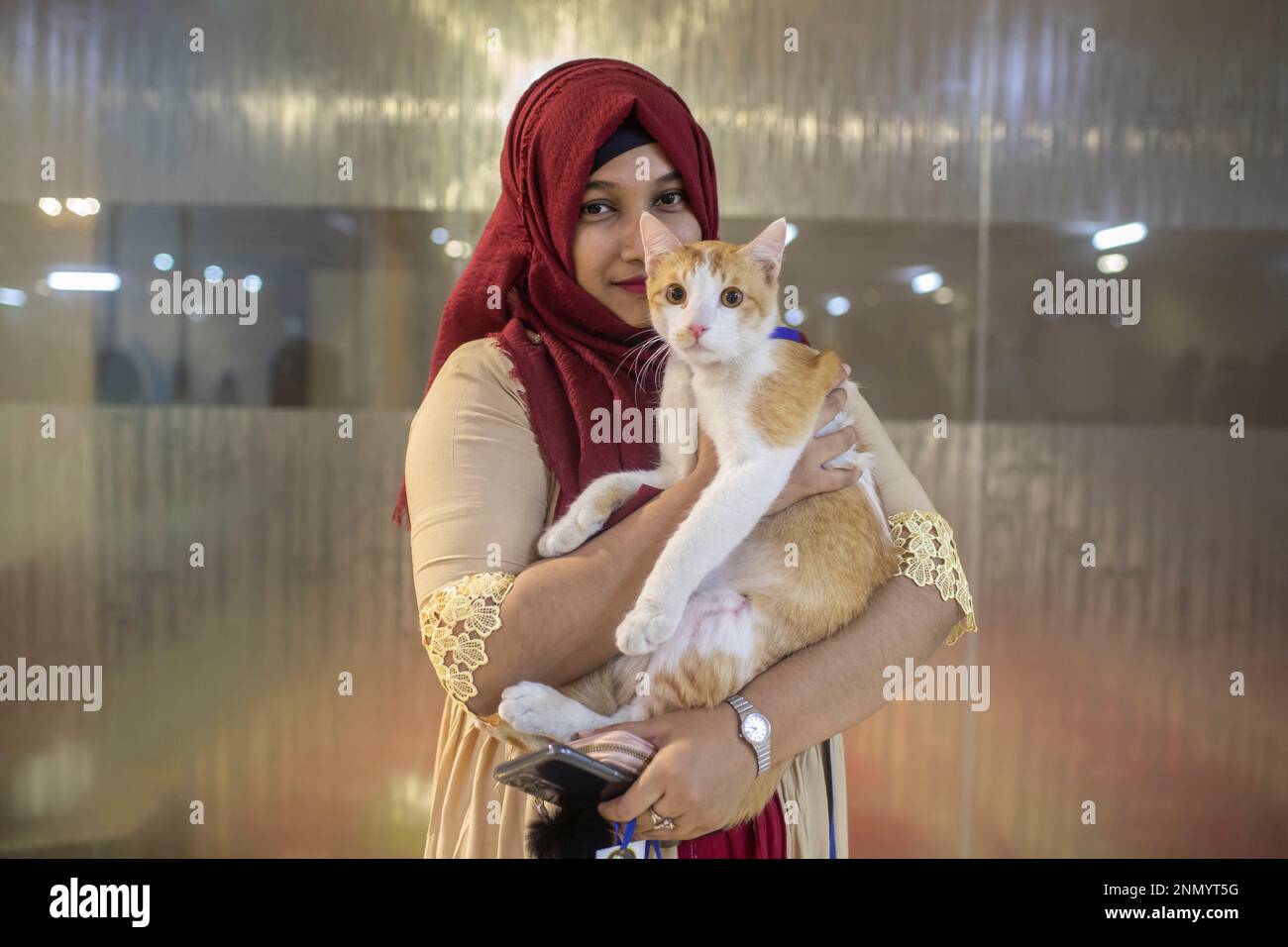 Dhaka, Bangladesh. 24th Feb, 2023. A cat owner shows off her pet cat during the cat ramp show at ...