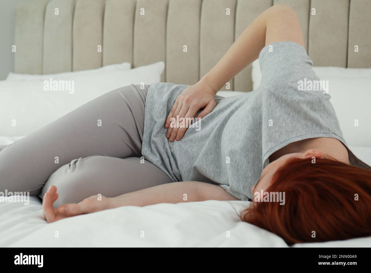 Woman suffering from appendicitis inflammation on bed at home Stock ...