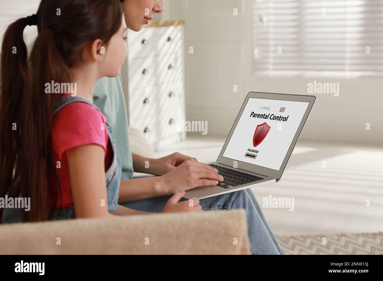 Mother installing parental control app on laptop to ensure her child's ...