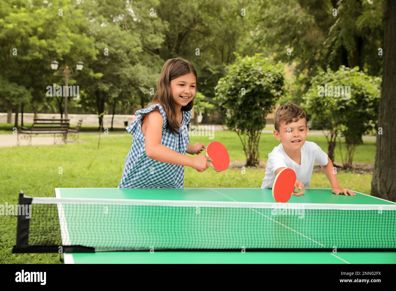 Little children playing ping pong in park Stock Photo - Alamy