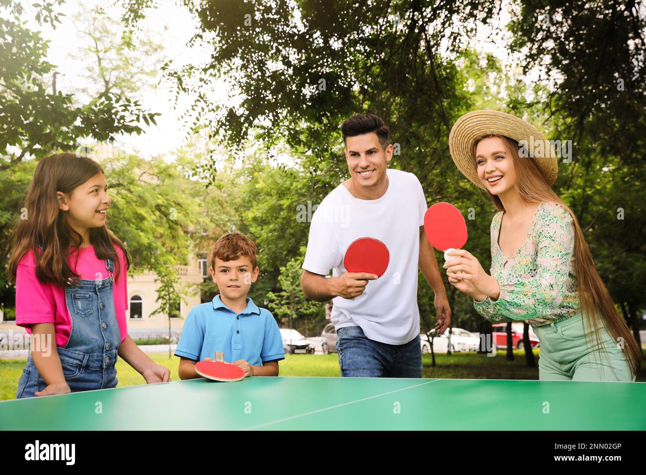 Happy family playing ping pong in park Stock Photo - Alamy