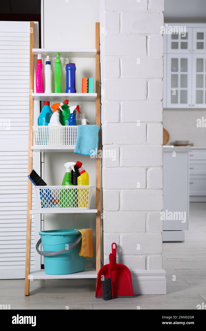 Rack with detergents, cleaning tools and accessories near white wall ...