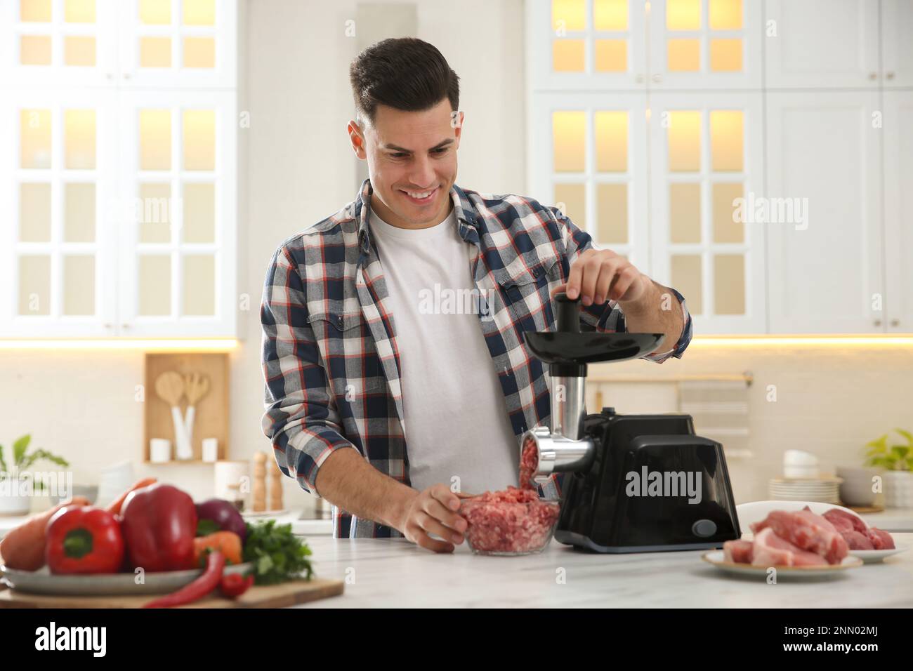 Man using modern meat grinder in kitchen Stock Photo - Alamy