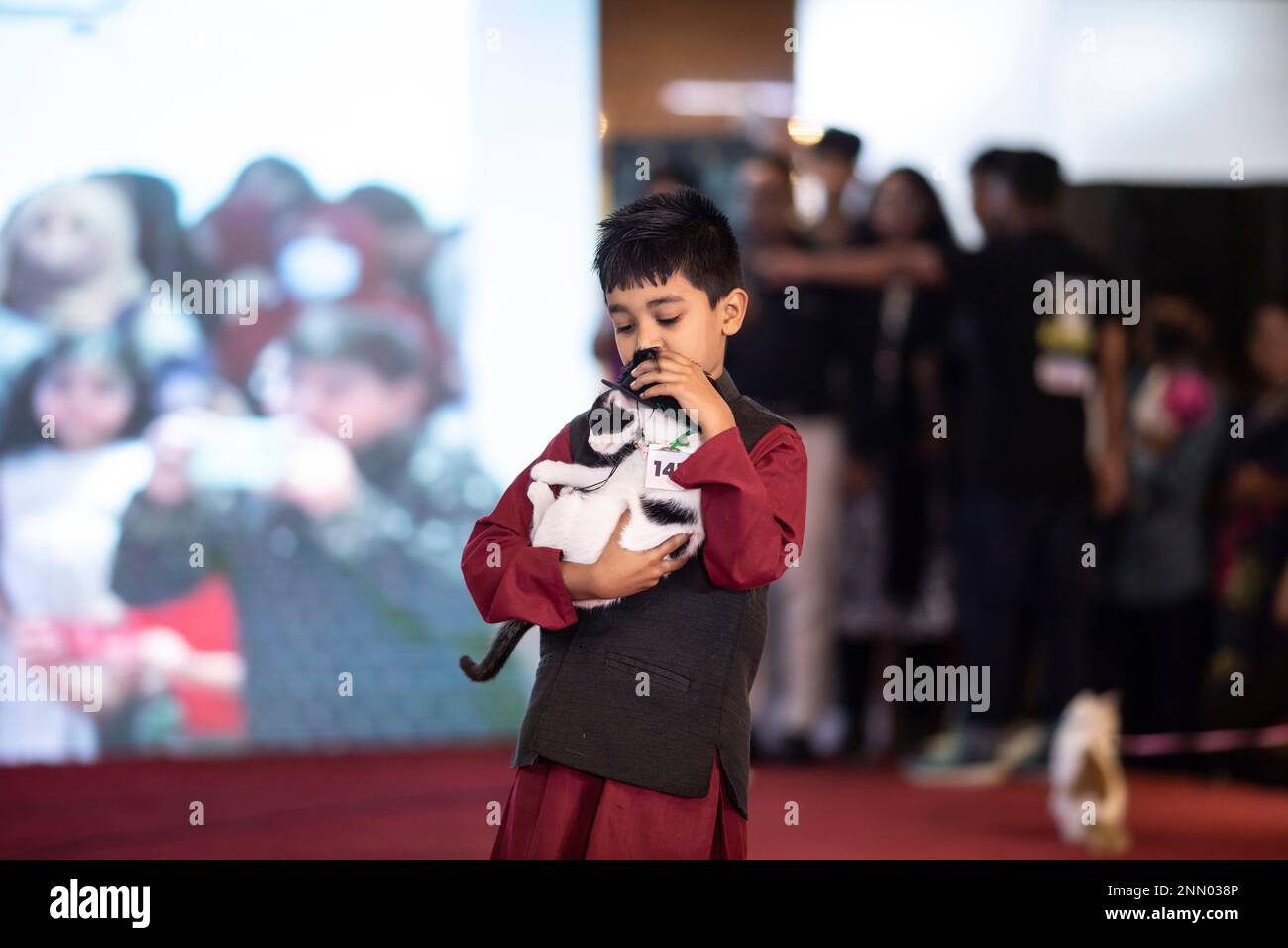 A young cat owner shows off his pet cat during the cat ramp show at ...