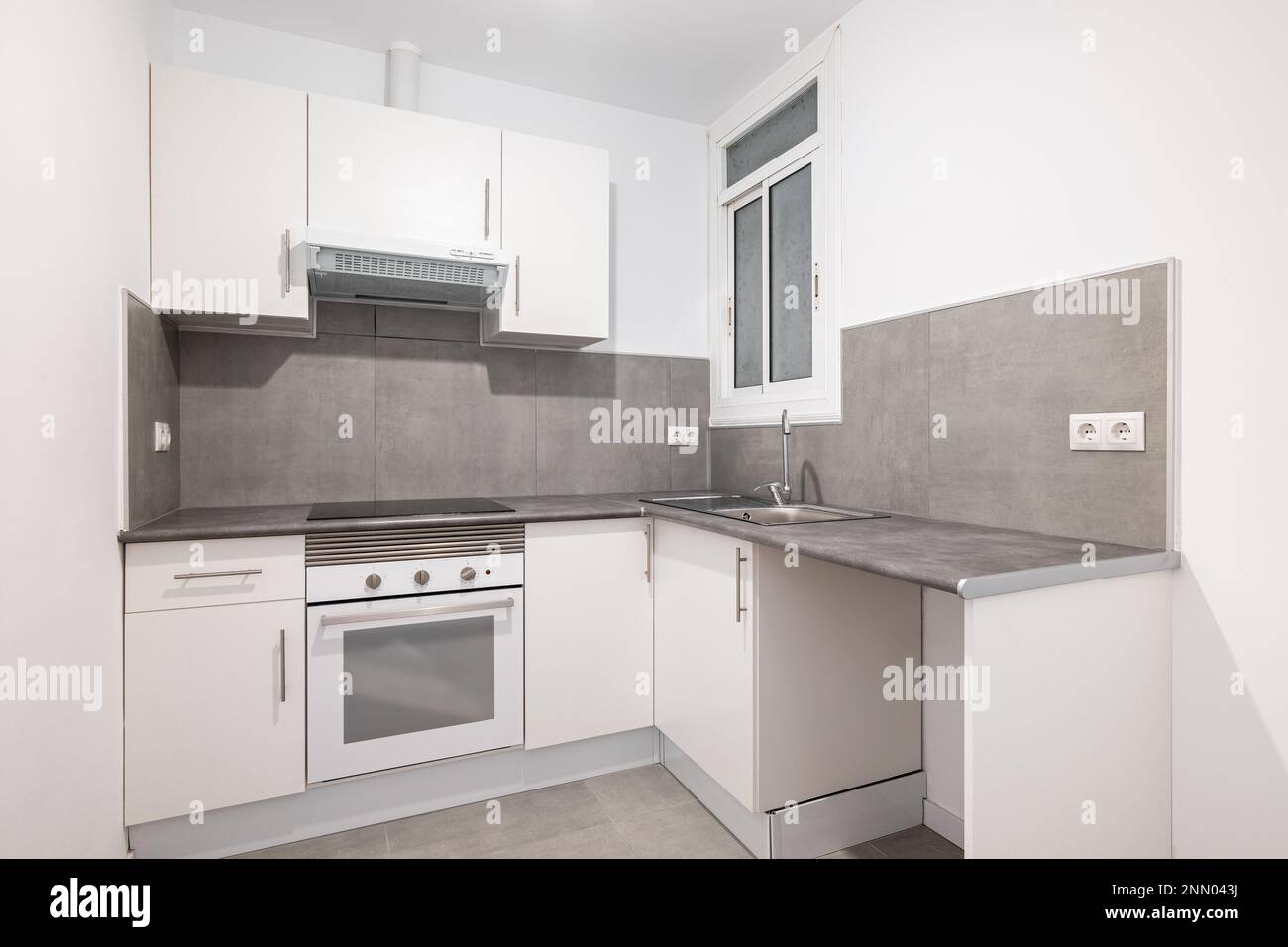 Light compact kitchen with stove, extractor hood and sink and window ...
