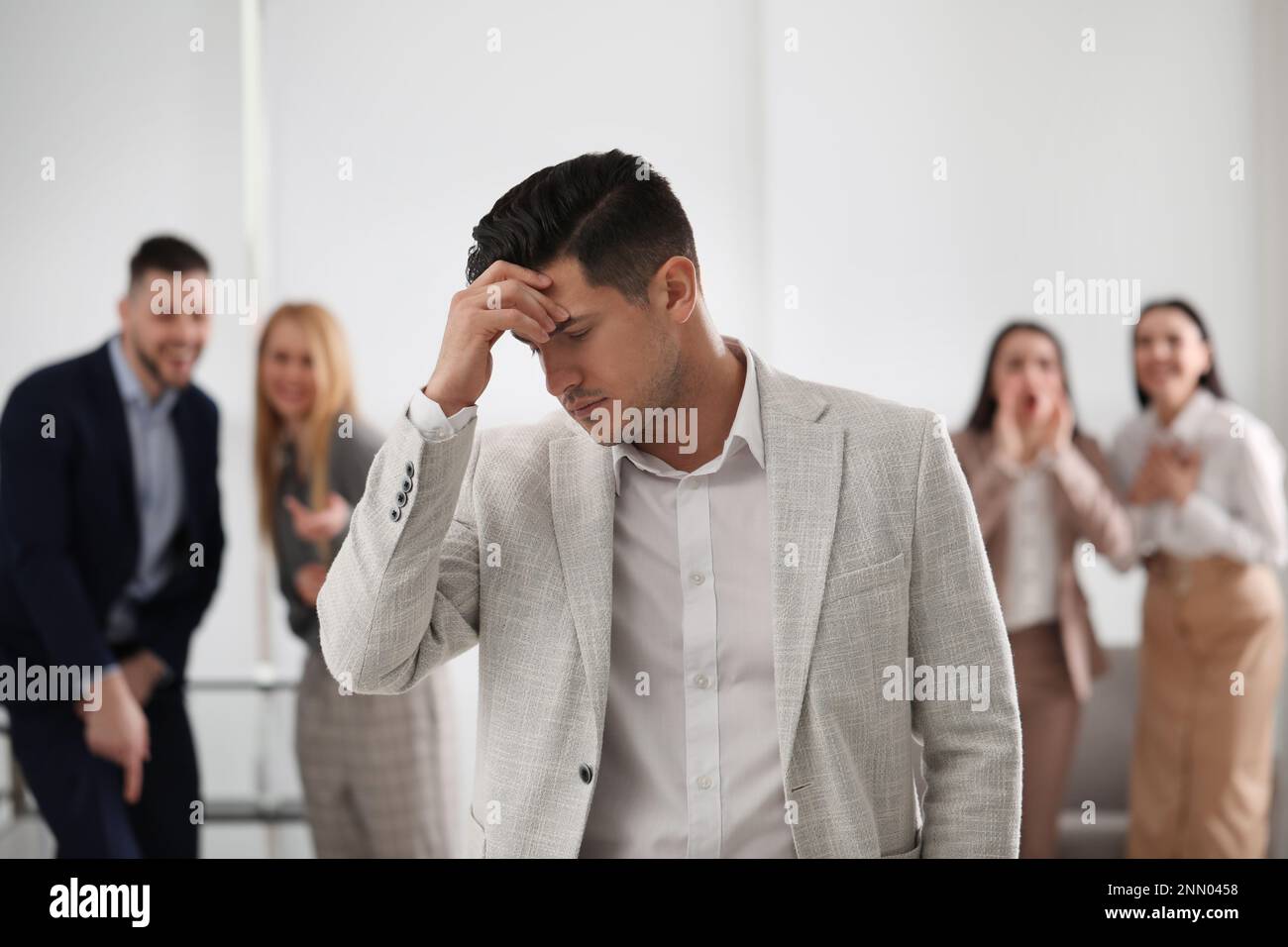 Group of coworkers bullying their colleague in office Stock Photo - Alamy