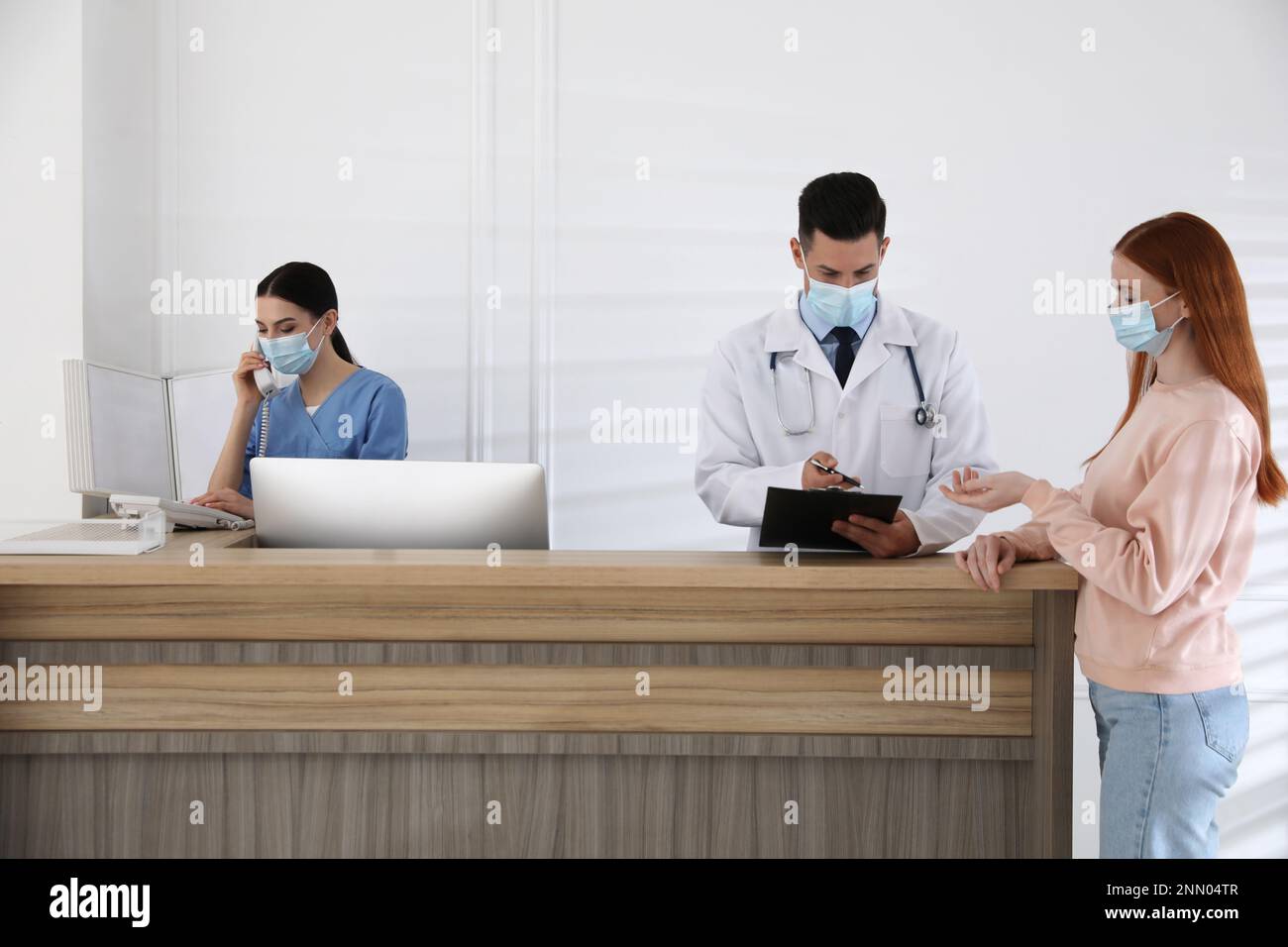 Patient talking receptionist hi-res stock photography and images - Alamy