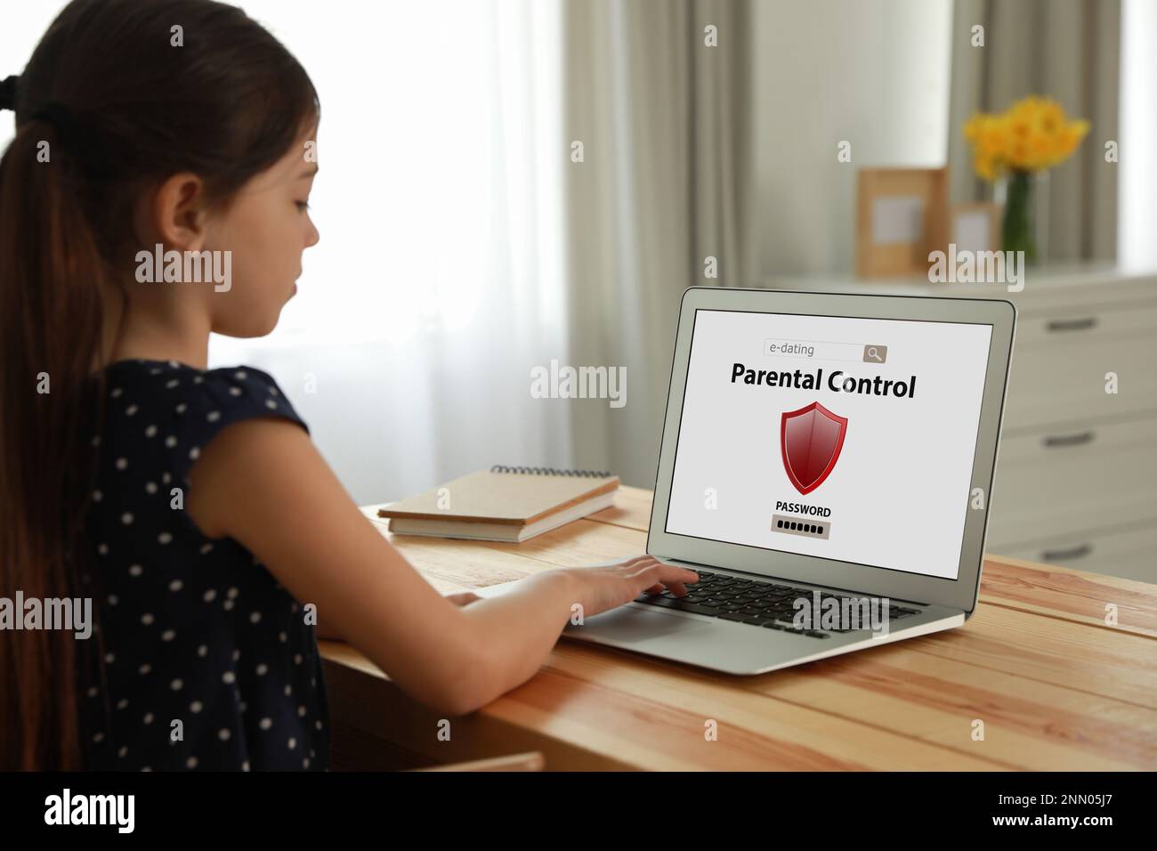 Child using laptop with installed parental control app at home. Cyber ...