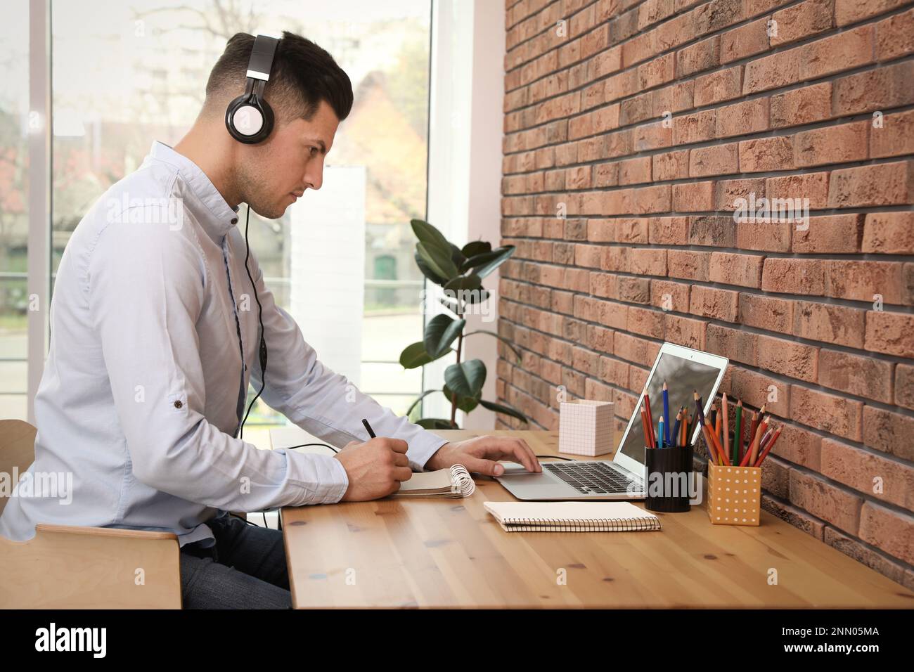 Man drawing in notebook at online lesson indoors. Distance learning ...