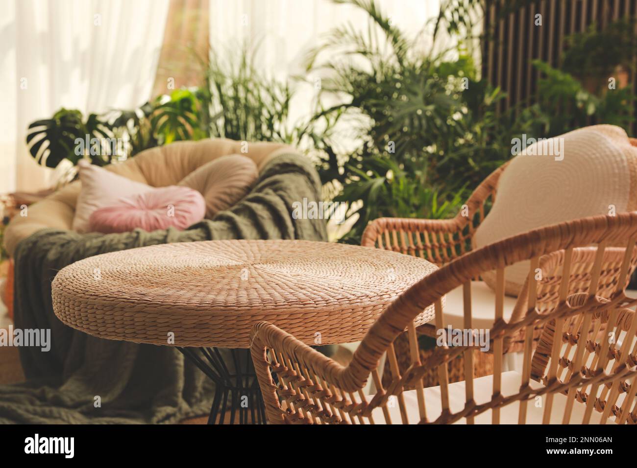 Indoor terrace interior with wicker furniture and green plants Stock ...