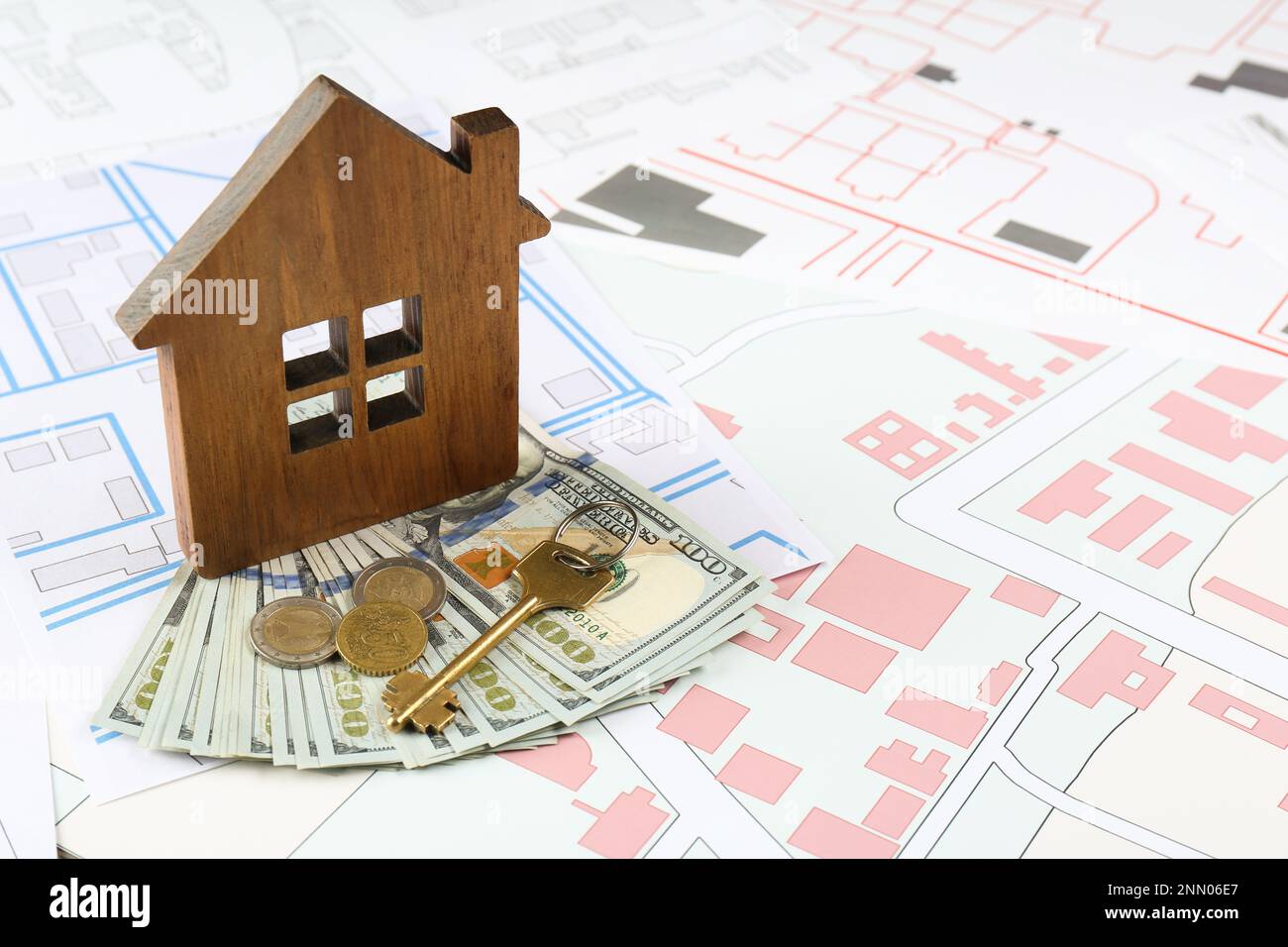 Money, key and wooden house model on cadastral maps Stock Photo - Alamy
