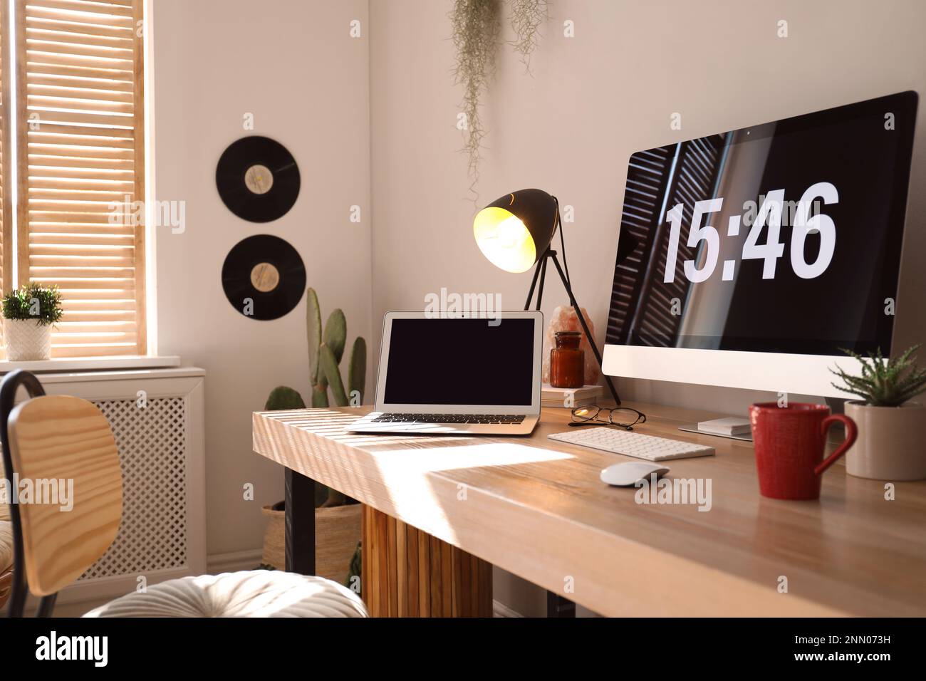 Modern computer and laptop on wooden desk in room. Interior design ...