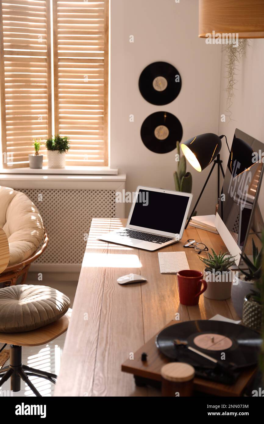 Modern computer and laptop on wooden desk in room. Interior design ...