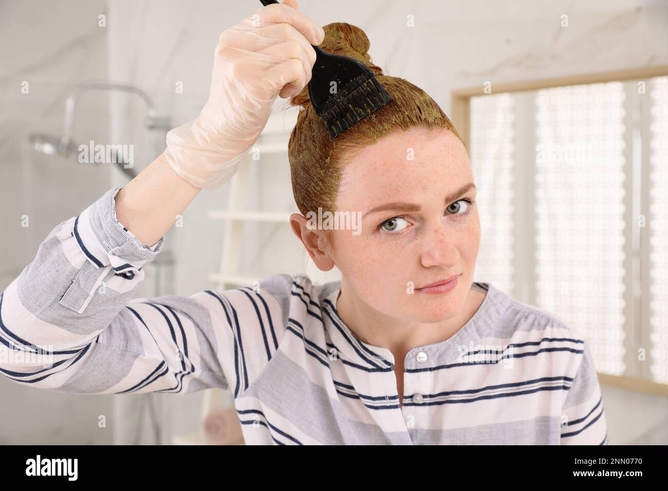Young woman dyeing her hair with henna in bathroom Stock Photo - Alamy