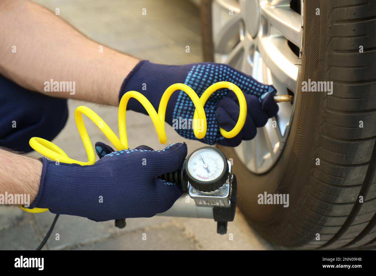 Mechanic measuring tire pressure at the auto repair shop Stock Photo ...