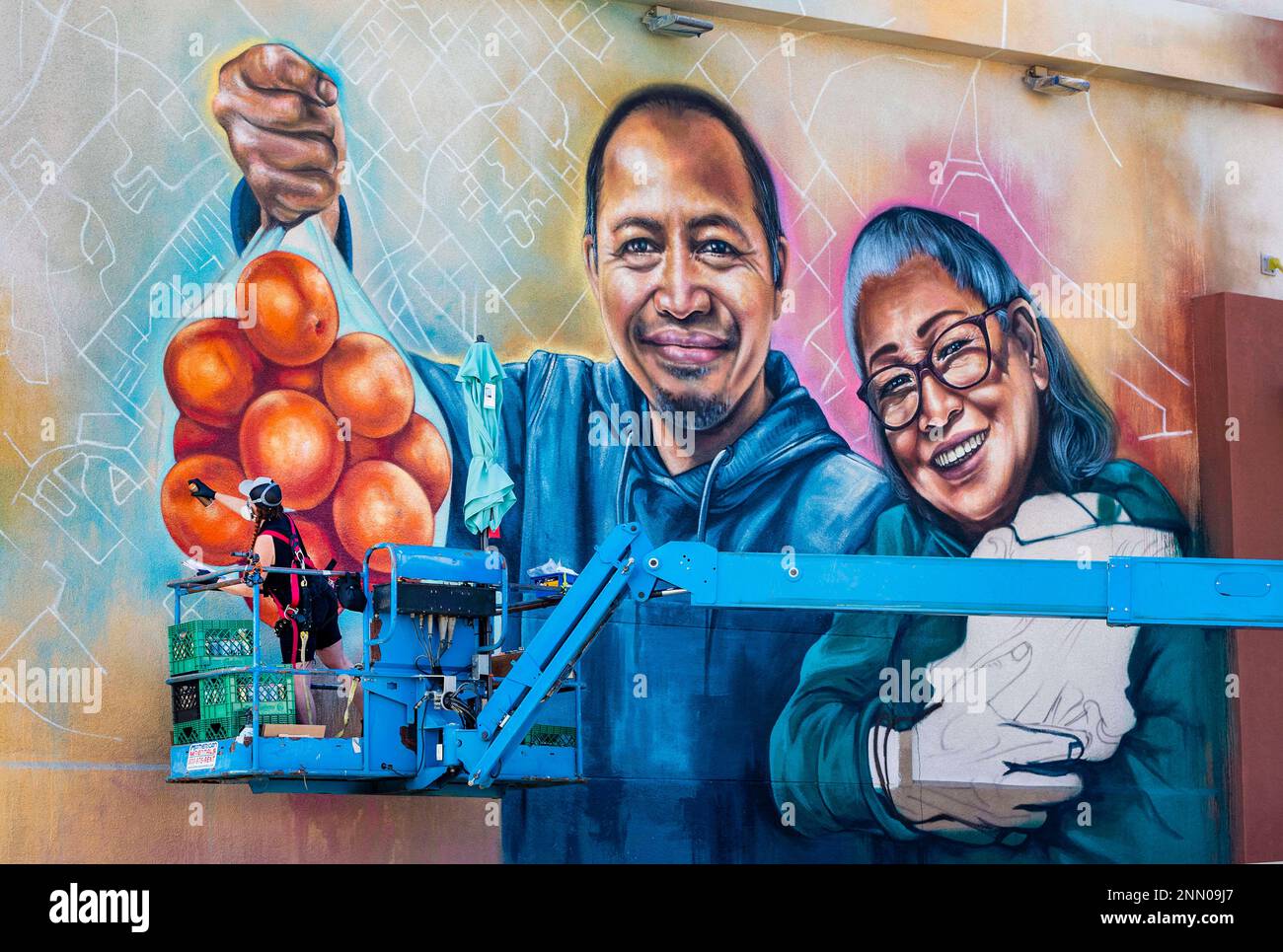 Artist Sarah Rutherford, bottom left, works on painting a two-story ...