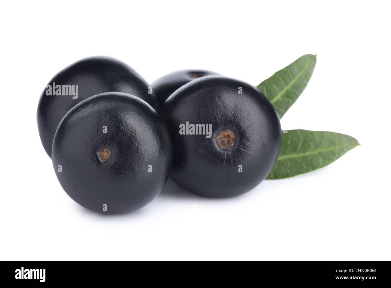 Pile of fresh ripe acai berries and green leaves on white background ...