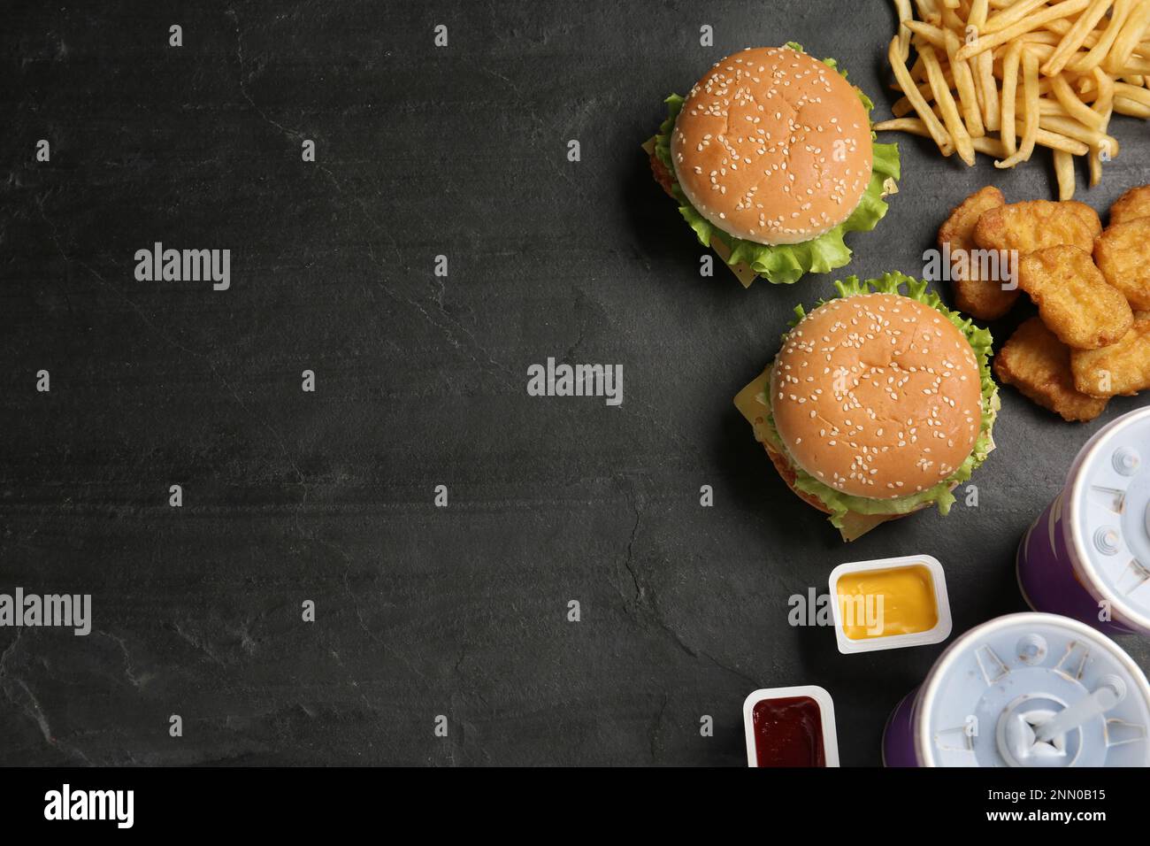 Flat lay composition with delicious fast food menu on black table ...