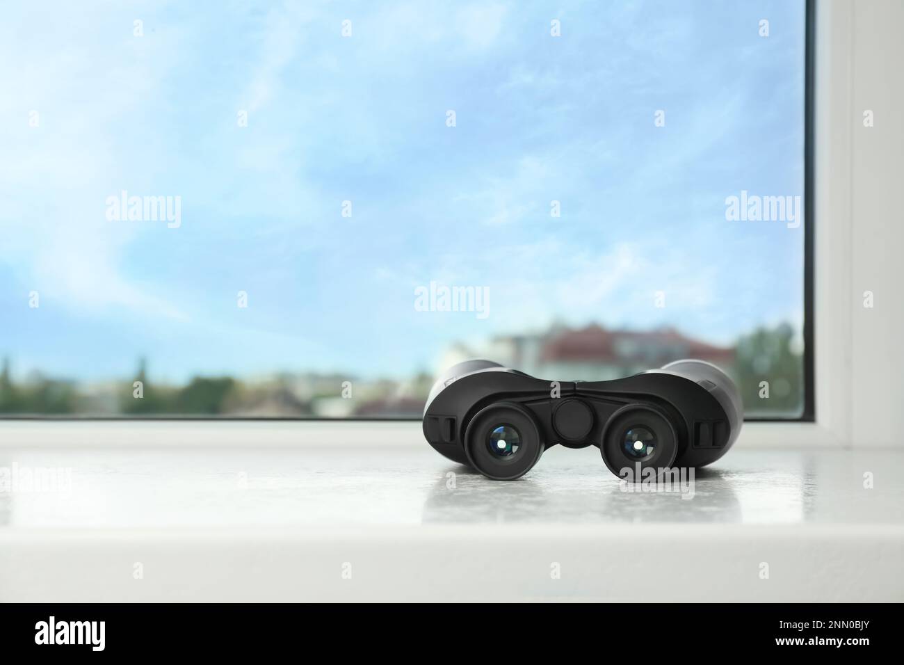 Black binoculars on white window sill. Space for text Stock Photo - Alamy
