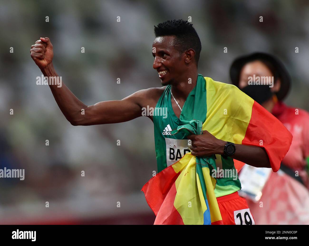 Ethiopia's BAREGA Selemon runs with his national flag after winning the ...
