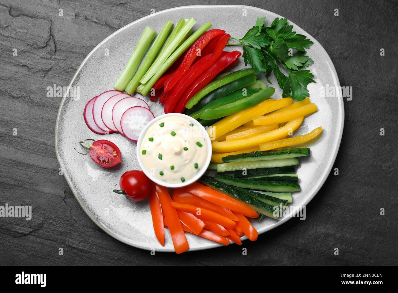 Fresh raw vegetable sticks and sauce on black table, top view Stock ...
