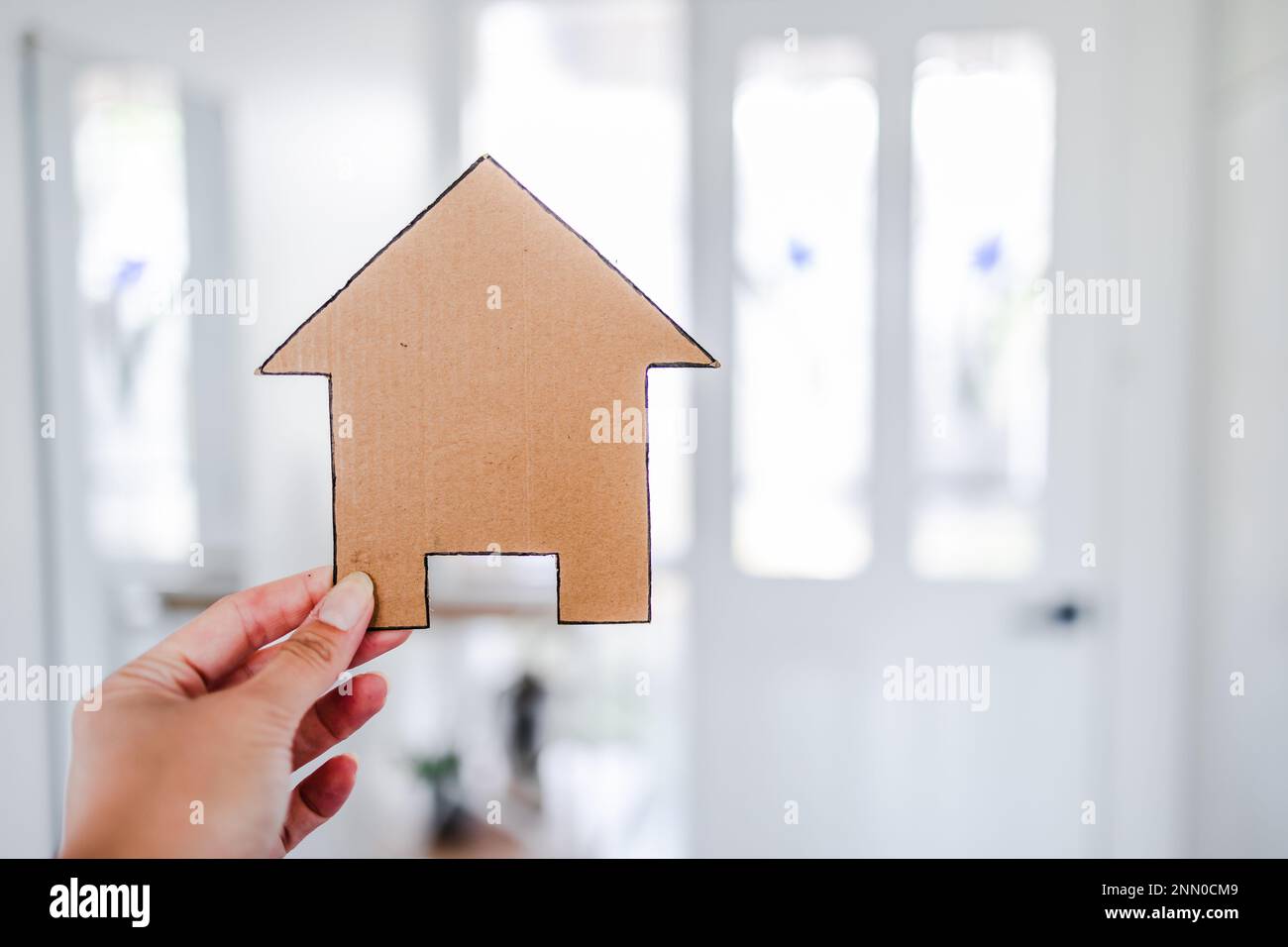 cardboard house in front of entry door bokeh with led light, concept of ...