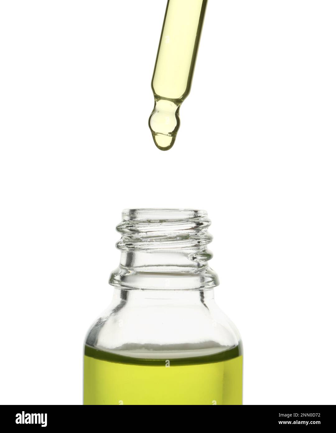 Dripping oil from pipette into glass bottle isolated on white, closeup ...