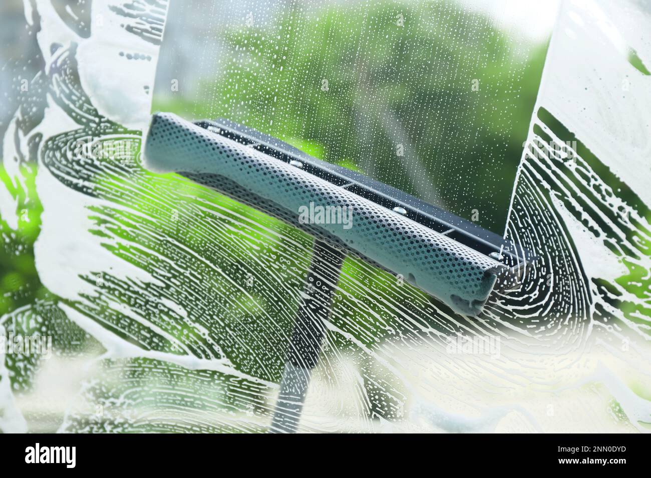 Washing window with squeegee from outside, view through glass Stock ...