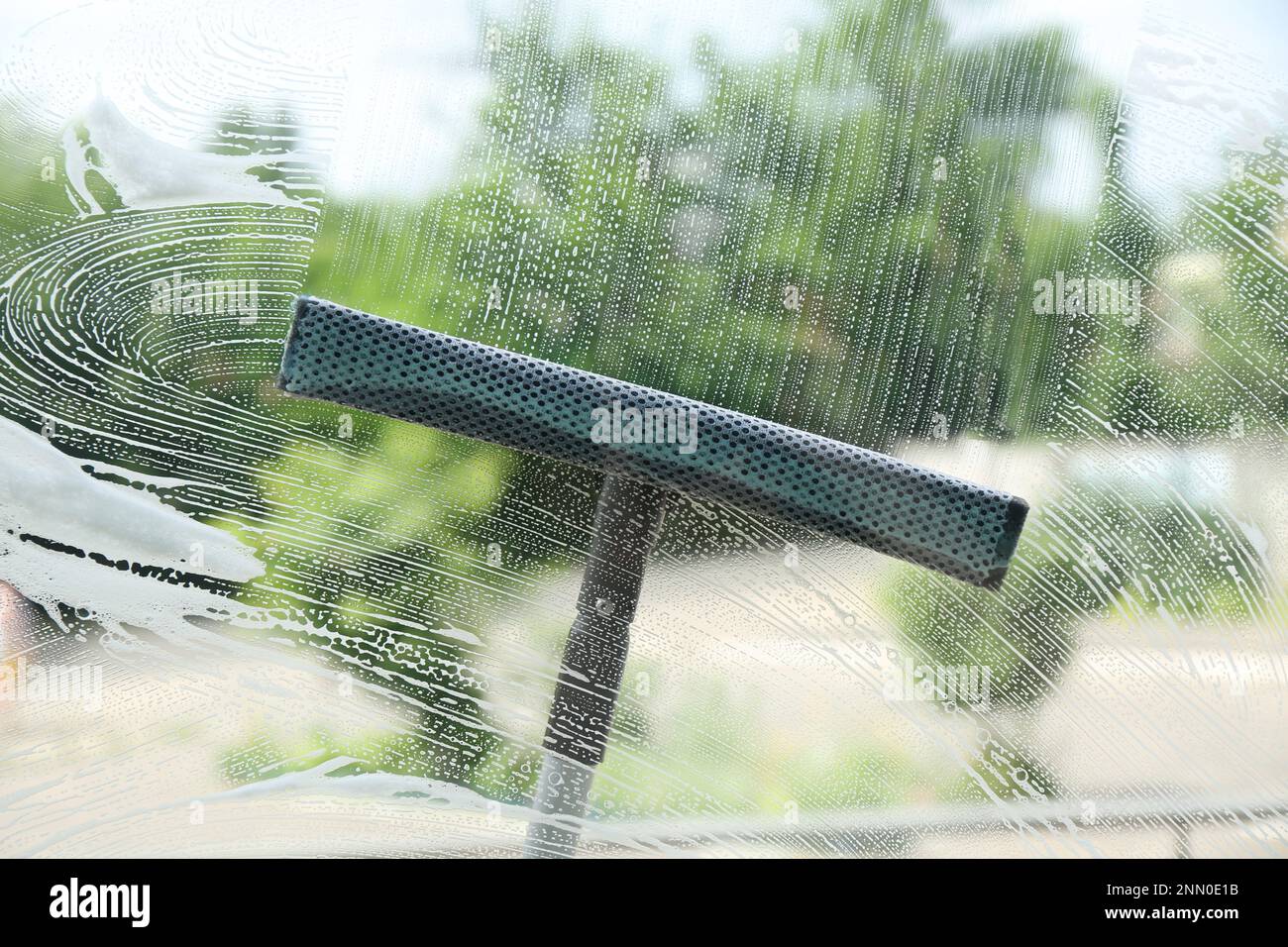 Washing window with squeegee from outside, view through glass Stock ...