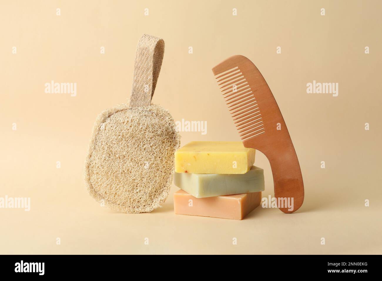 Natural loofah, bamboo hair comb and soap bars on beige background ...