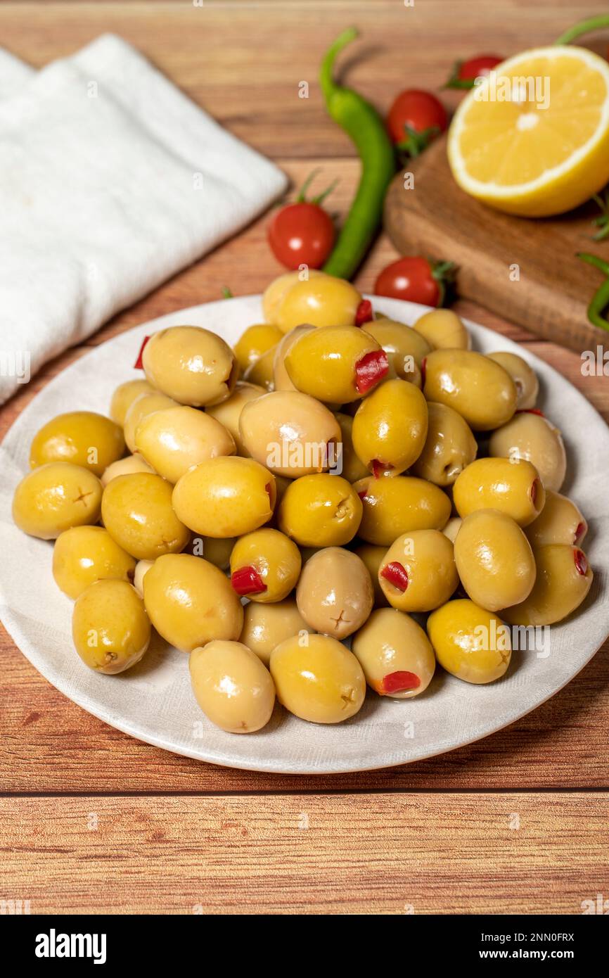 Stuffed olives. Green olives stuffed with dry peppers on a wooden ...